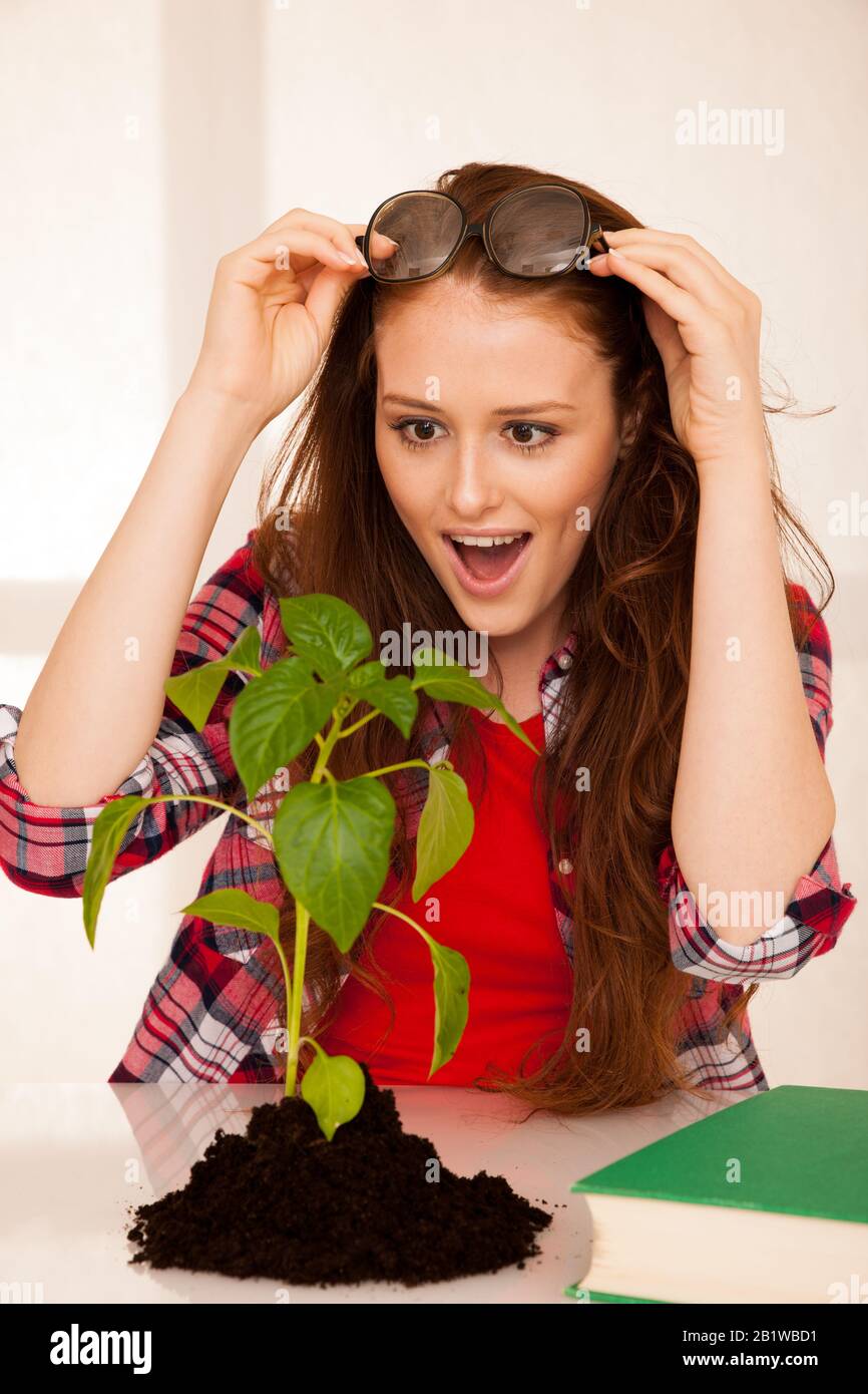attractive young botany student with seedlnng and books Stock Photo - Alamy