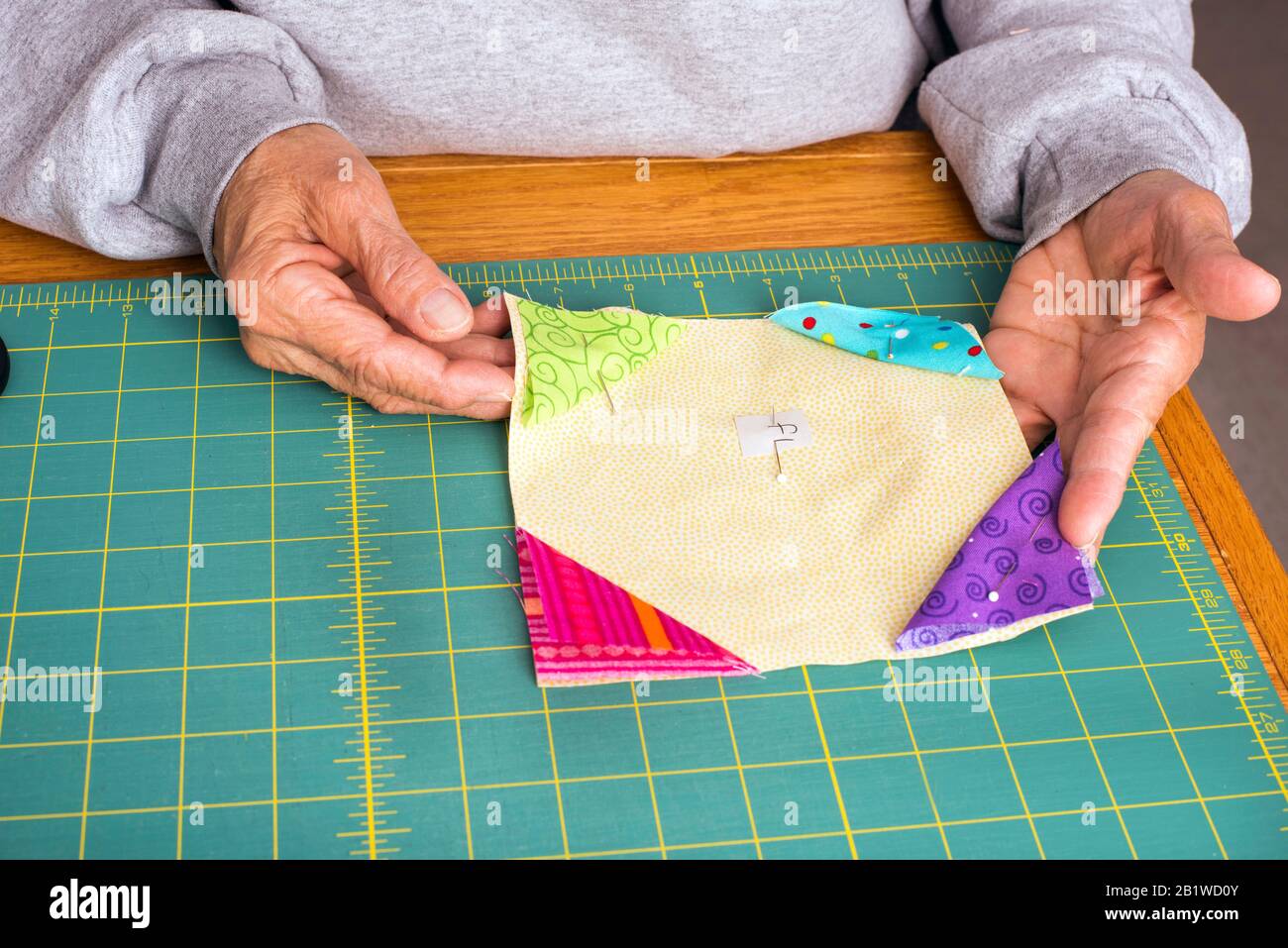 A single square of cotton fabric is pinned and labeled before final ...