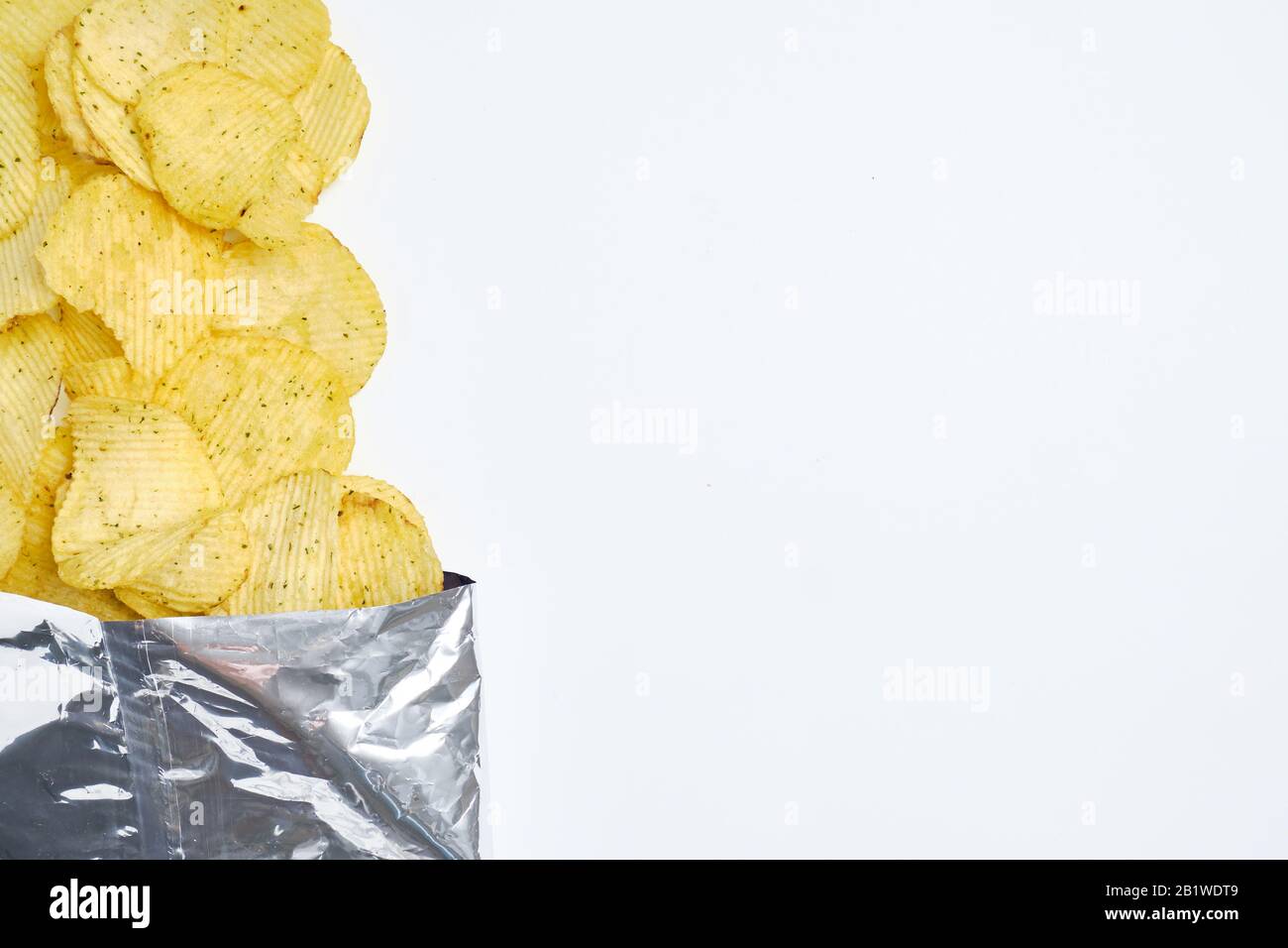 Corrugated chips fall out of foil packaging on a white background ...
