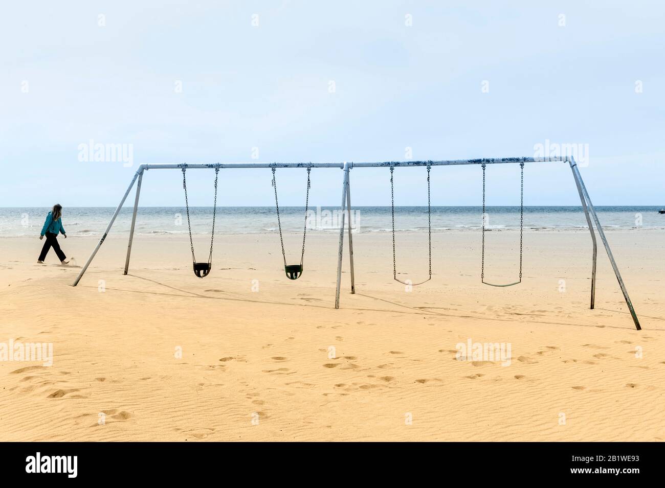 Beachcomber walking past swing set at Douglas Park, First Street Beach ...