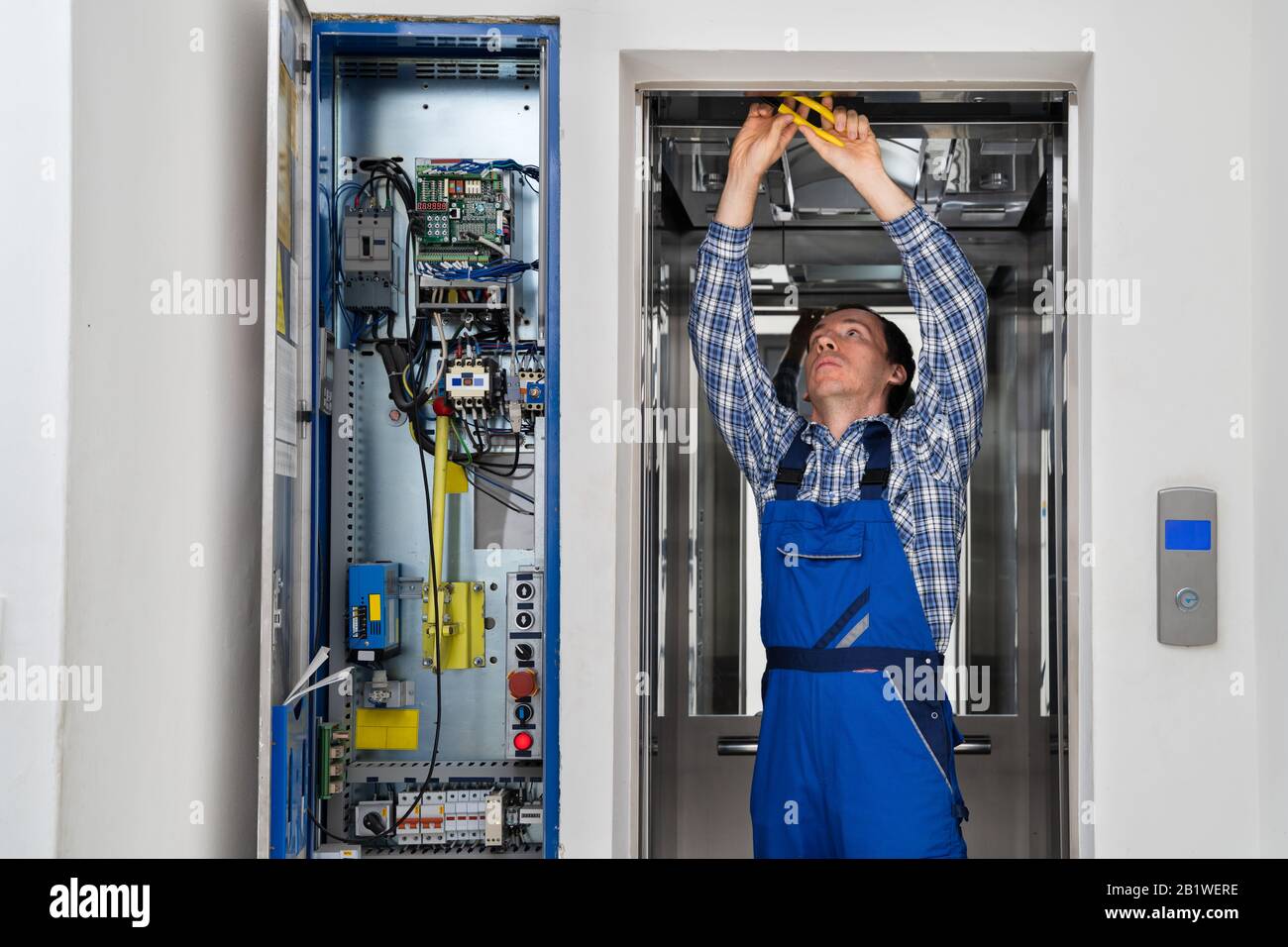 Technician Repairing Control Panel Of Broken Elevator Stock Photo - Alamy