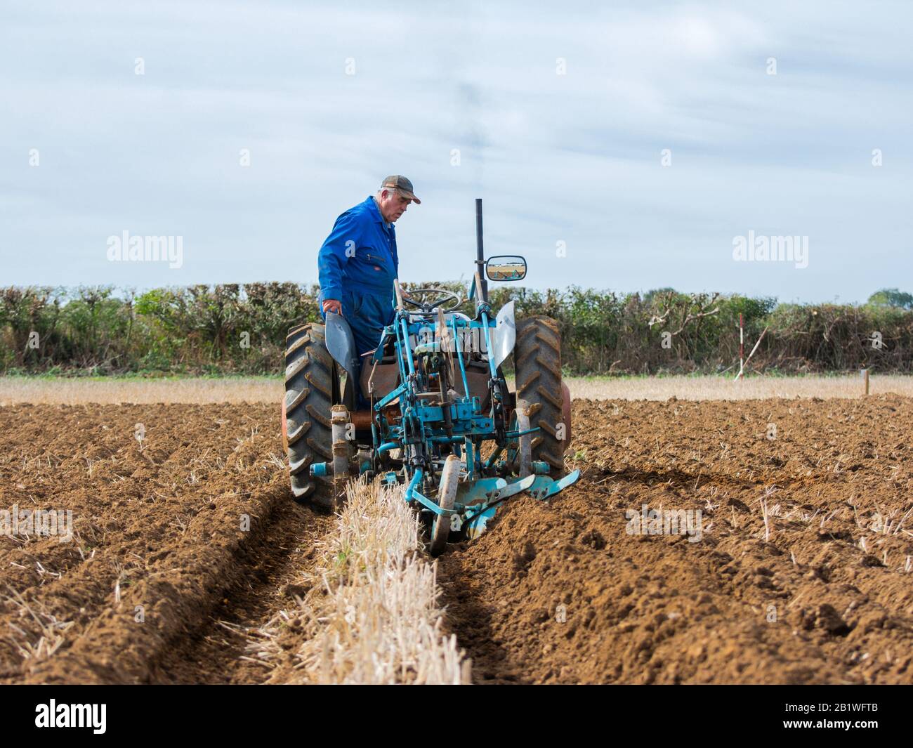 Vintage class small grey gray tractor Ploughing furrow field plough ...