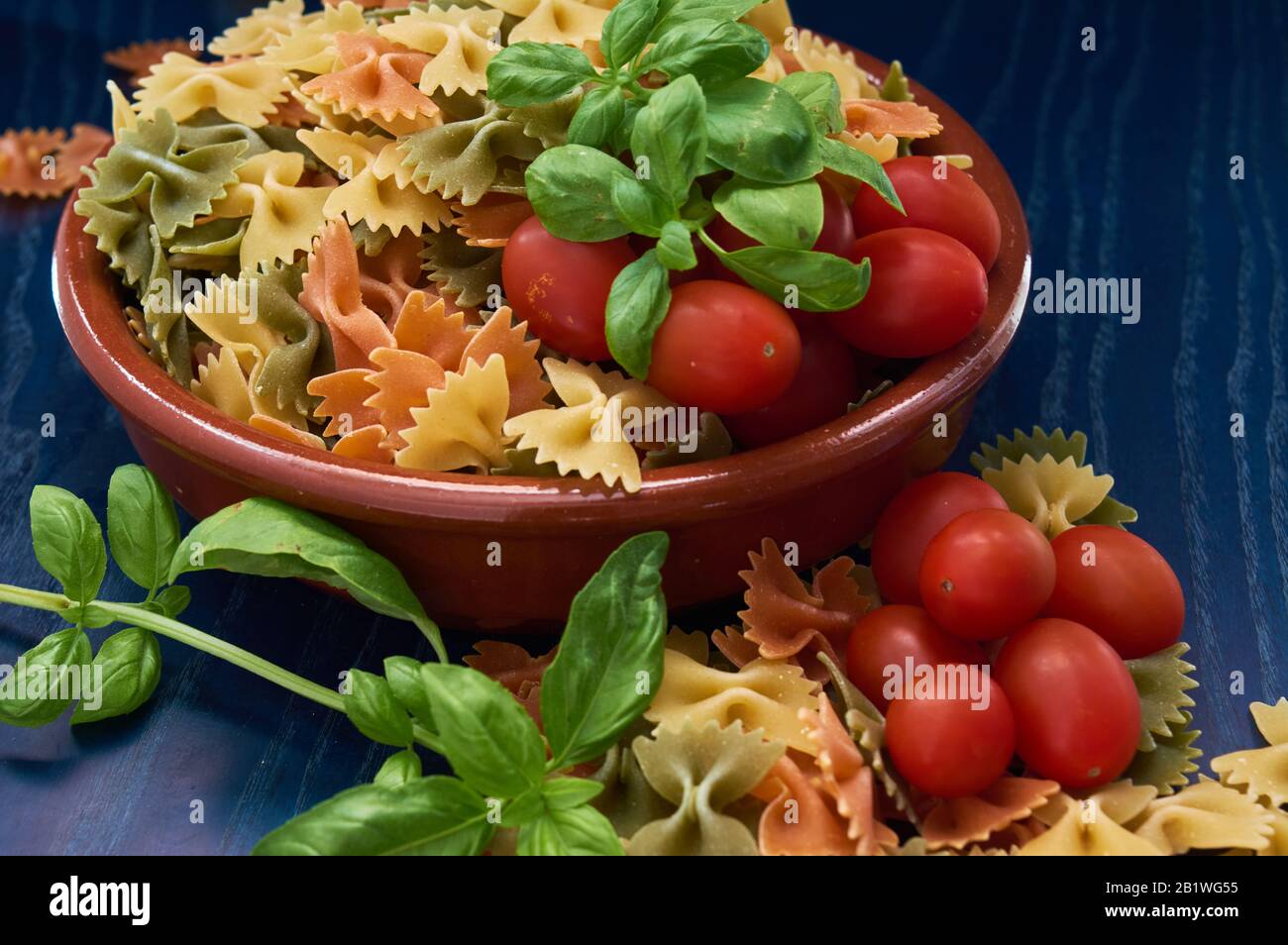 loop pasta, bright natural colors, basil green and red tomatoes, with ...