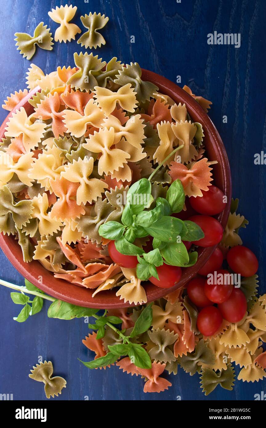 loop pasta, bright natural colors, basil green and red tomatoes, with ...