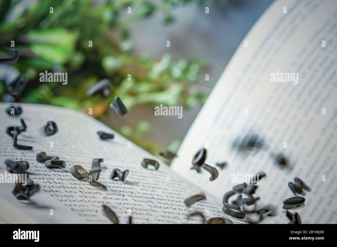 open book with falling black letters Stock Photo - Alamy