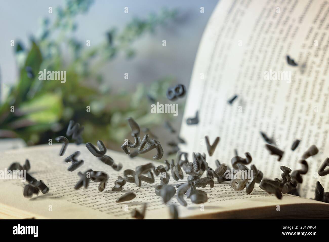 open book with falling black letters Stock Photo - Alamy