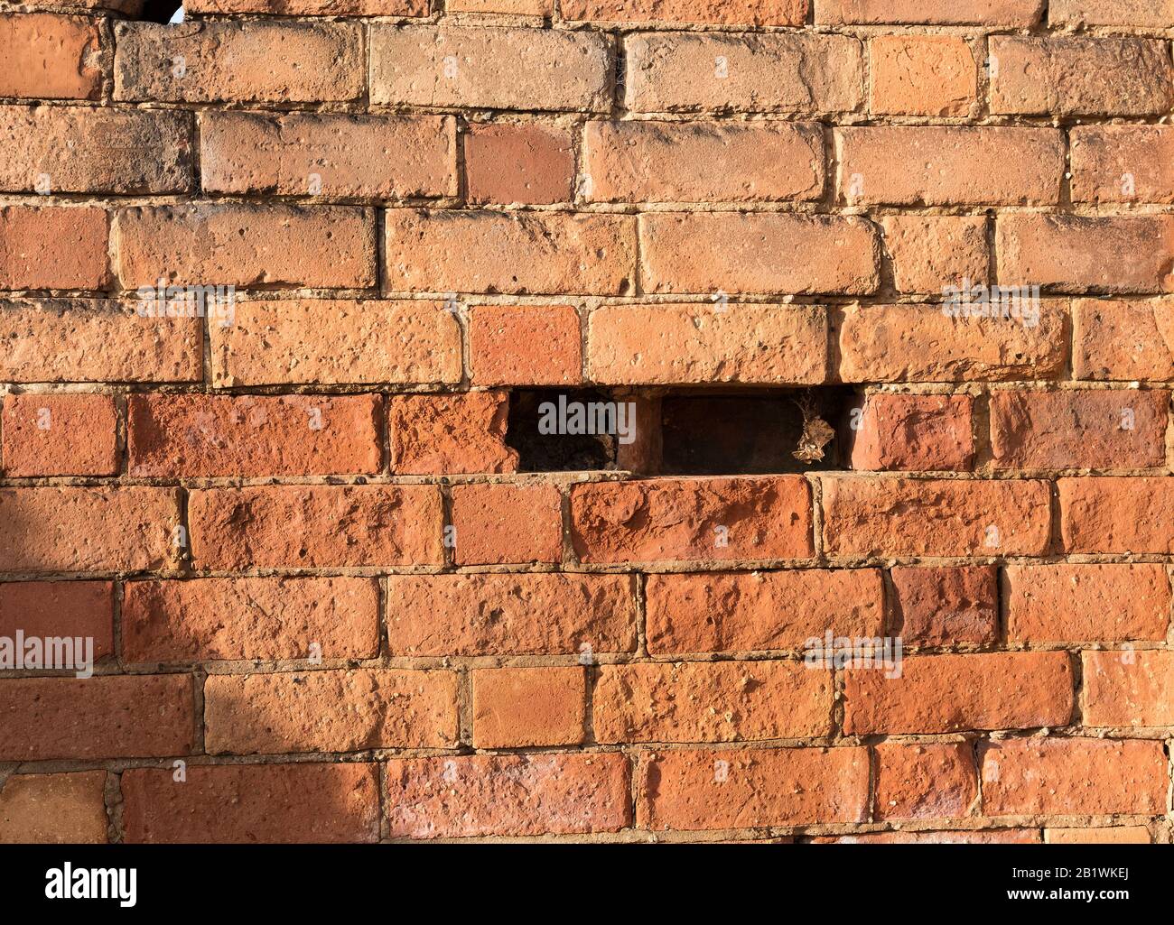 Missing brick in a crumbling brick wall Stock Photo - Alamy