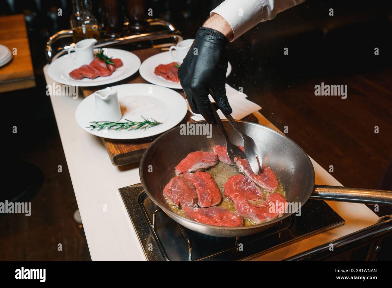 Chef turning over frying tenderloin beef steaks Stock Photo - Alamy