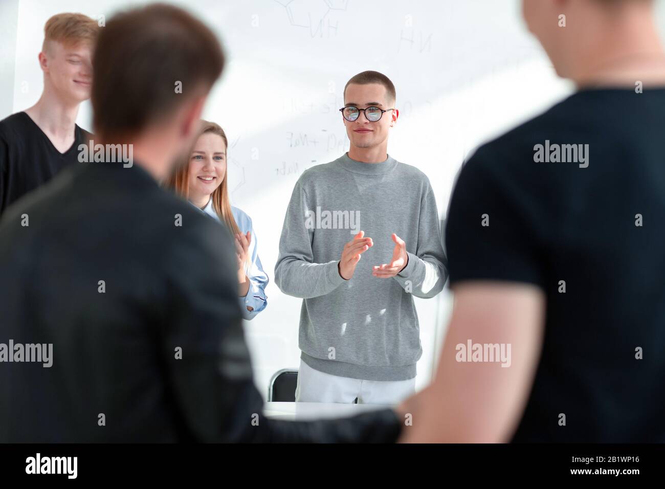 group of diverse young people standing around a round table Stock Photo ...