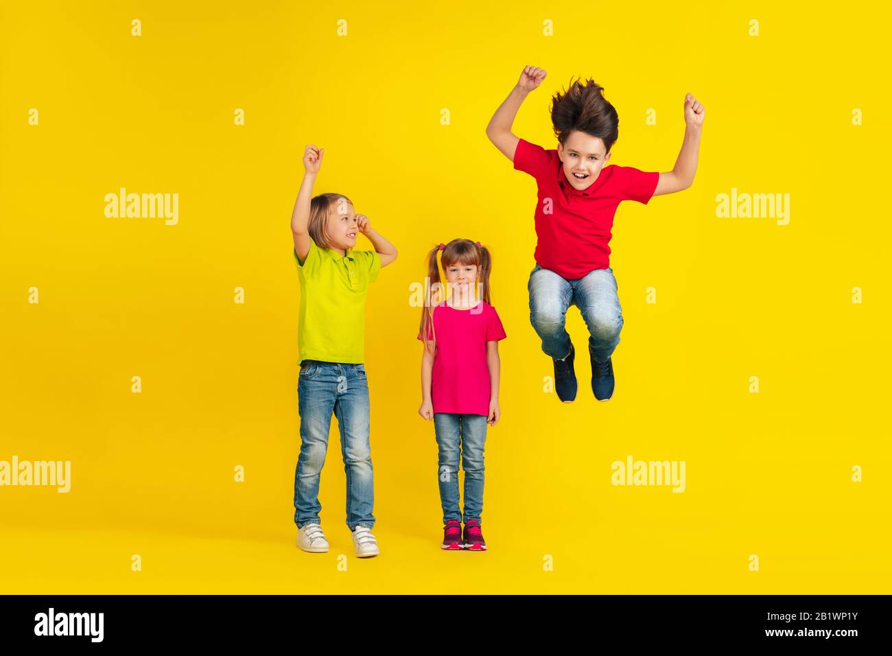 Jump high. Happy children playing and having fun together on yellow ...