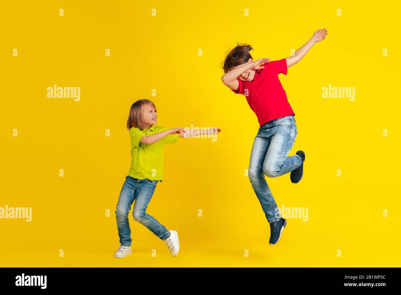 Winner. Happy children playing and having fun together on yellow studio ...