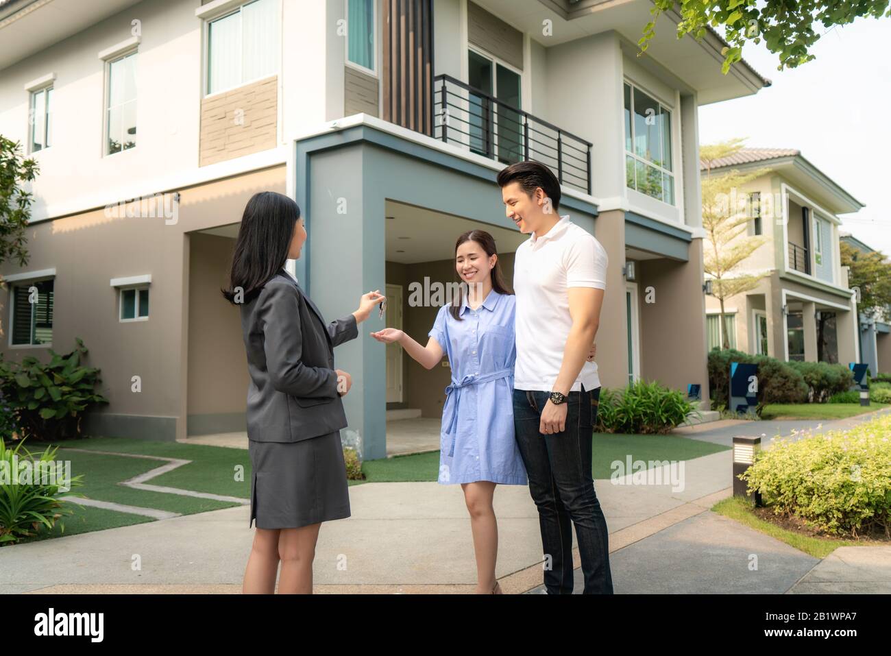Asian happy smile young couple take keys new big house from real estate ...
