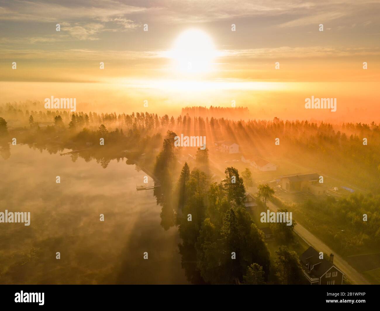 drone photo of beautiful foggy sunrise over forest, lake and village in ...