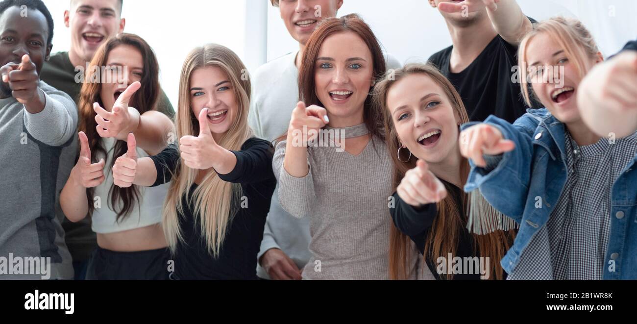 group of smiling young people pointing at one point Stock Photo - Alamy