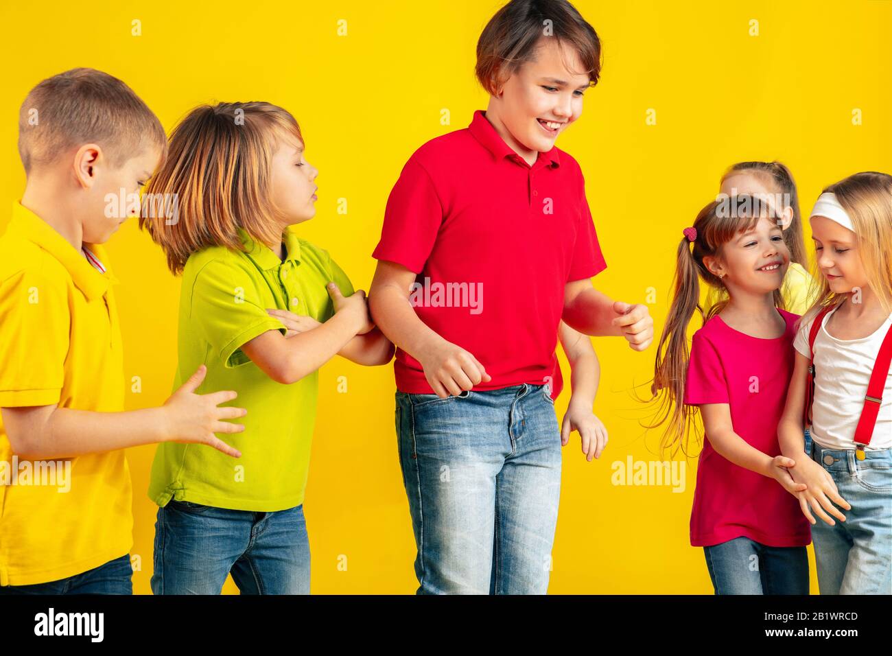 Happiness. Happy children playing and having fun together on yellow ...