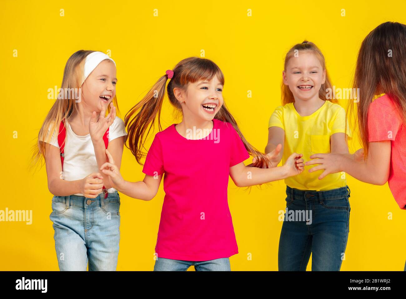 Happiness. Happy children playing and having fun together on yellow ...