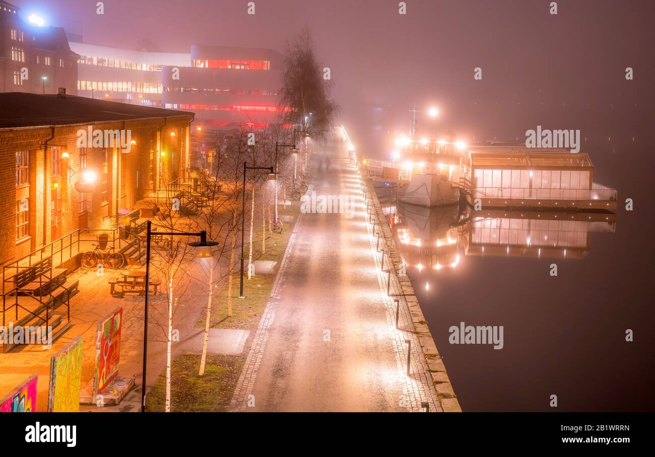 Very foggy night, view from the bridge to the embankment of Umea river ...