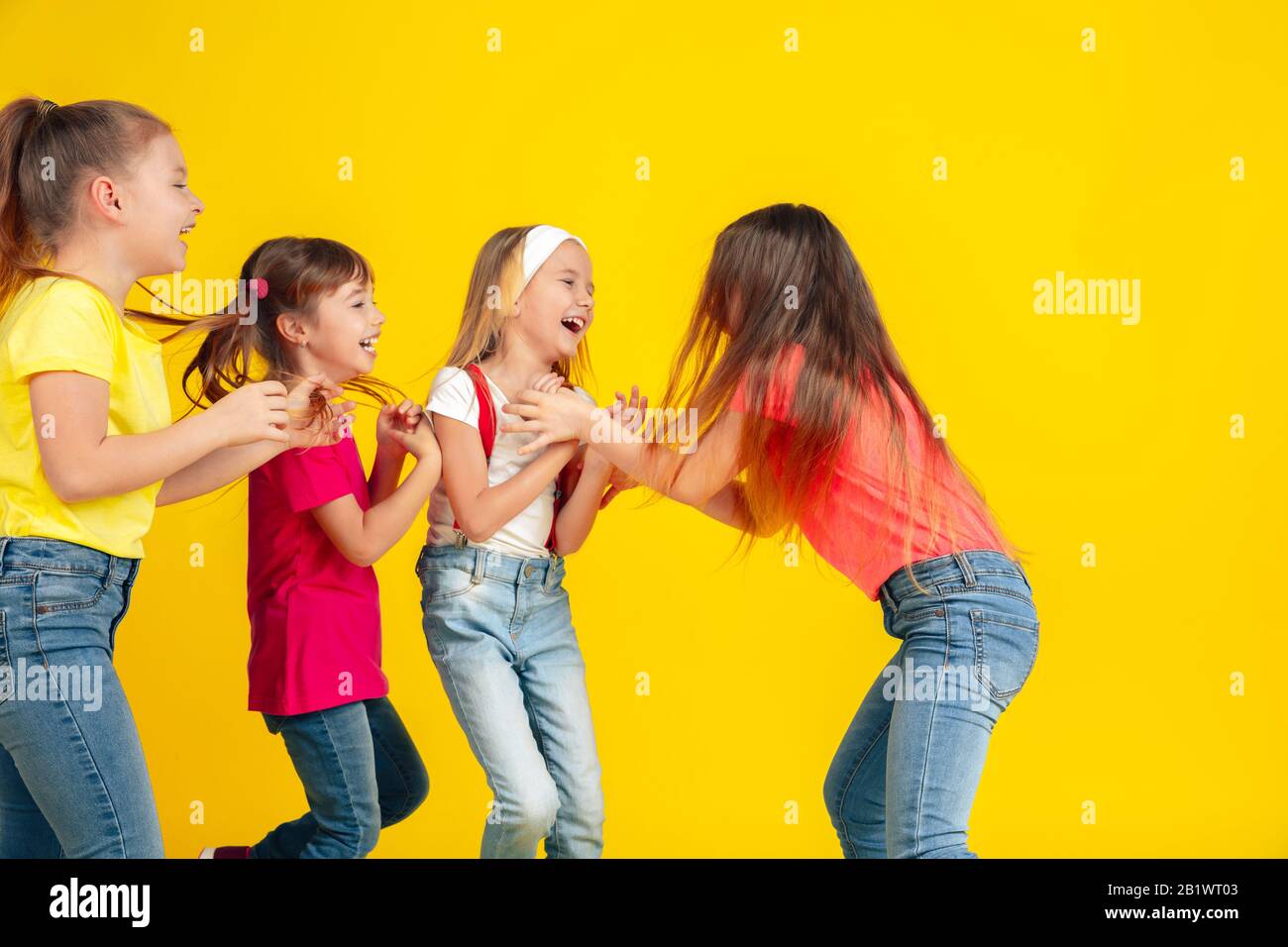 Happiness. Happy children playing and having fun together on yellow ...