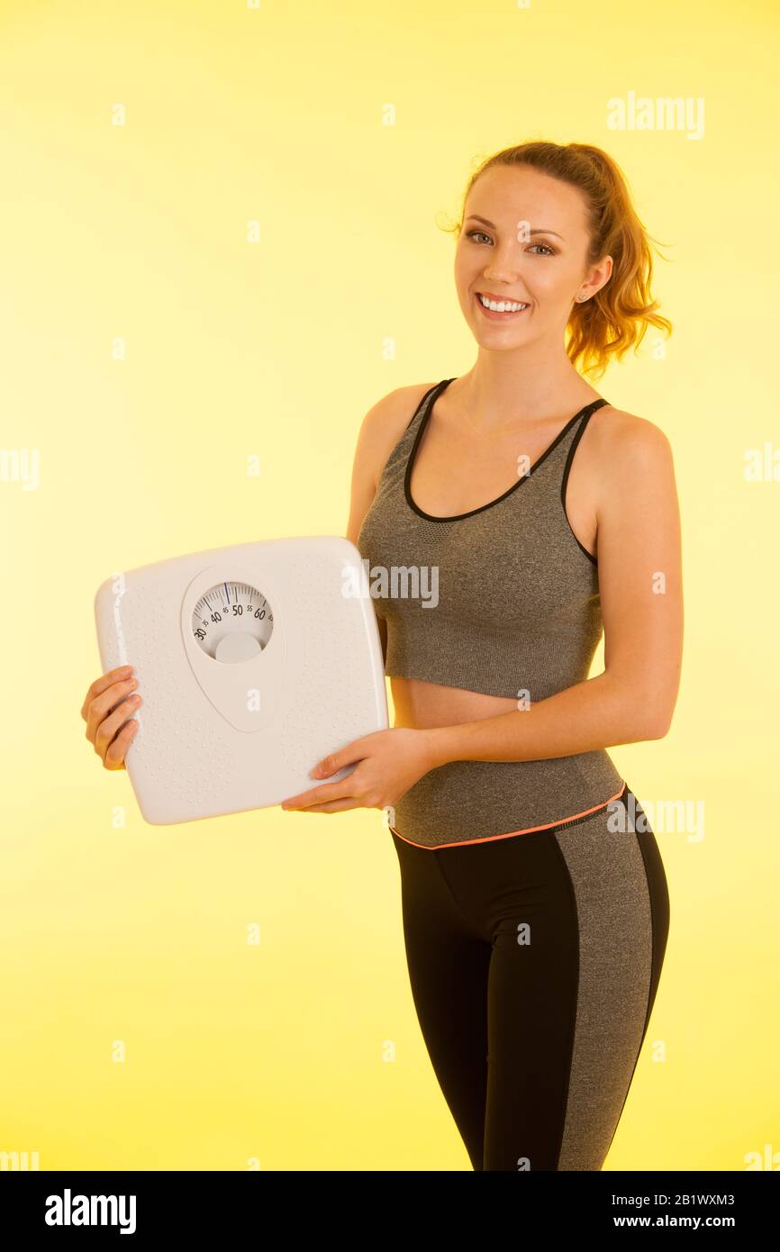 Beautiful young active fit woman hold scale as gesture of loosing ...