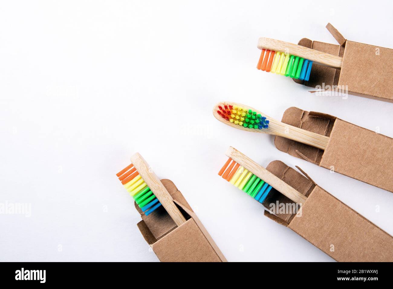Bamboo toothbrushes in a cardboard packaging with copy space on a white ...