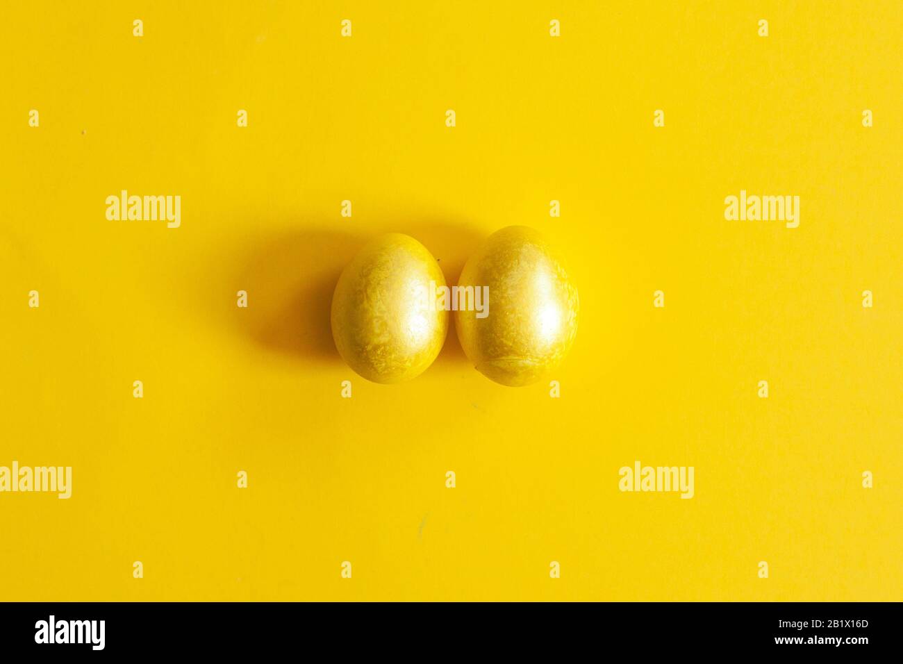 Golden testicles. Easter eggs on yellow. Two eggs on yellow background ...