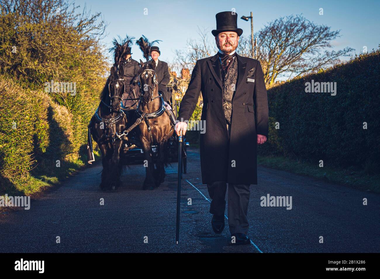 A funeral director, dressed in traditional formal morning dress with ...