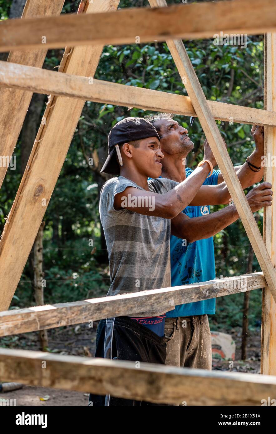 hispanic father and son working together building a house in guatemala ...