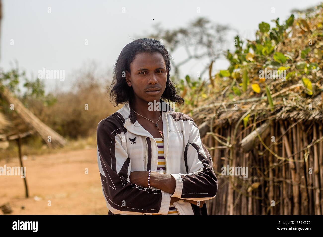 A Hausa/Fulani boy pose for photo in front a thatch house in a village ...