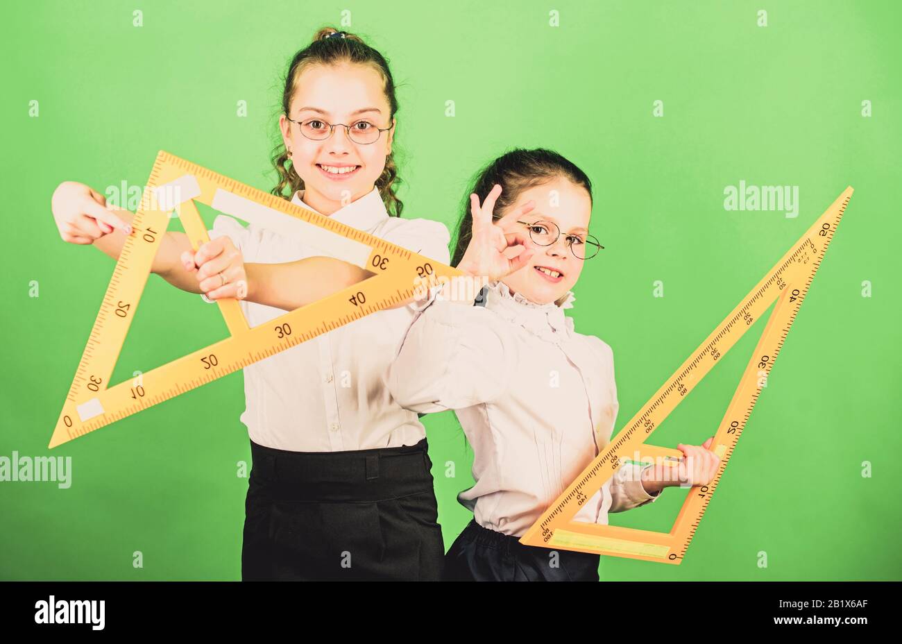 Pupil cute girls with big rulers. STEM school disciplines. math lesson ...