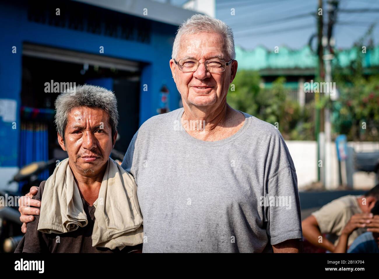 elderly caucasian man takes photo with homeless hispanic man after ...