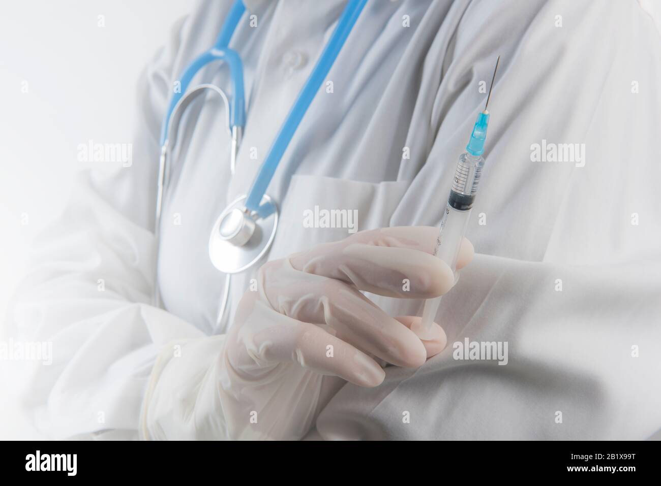 Doctor hand in white glove hold syringe with preparation jet from the ...