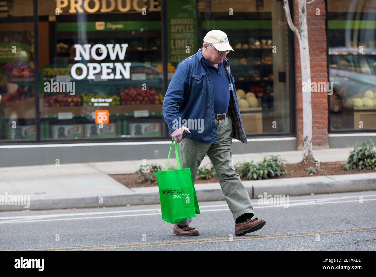 A customer crosses Pike Street after shopping at Amazon Go Grocery on ...