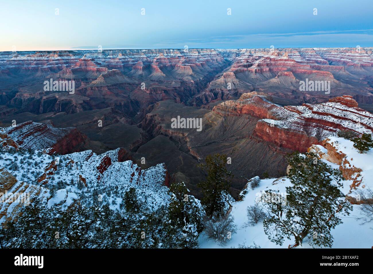A blue twilight sky just after sunset with a dusting of winter snow at ...