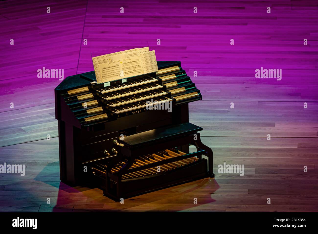 a modern electric organ is placed on the stage lit by lights, waiting ...