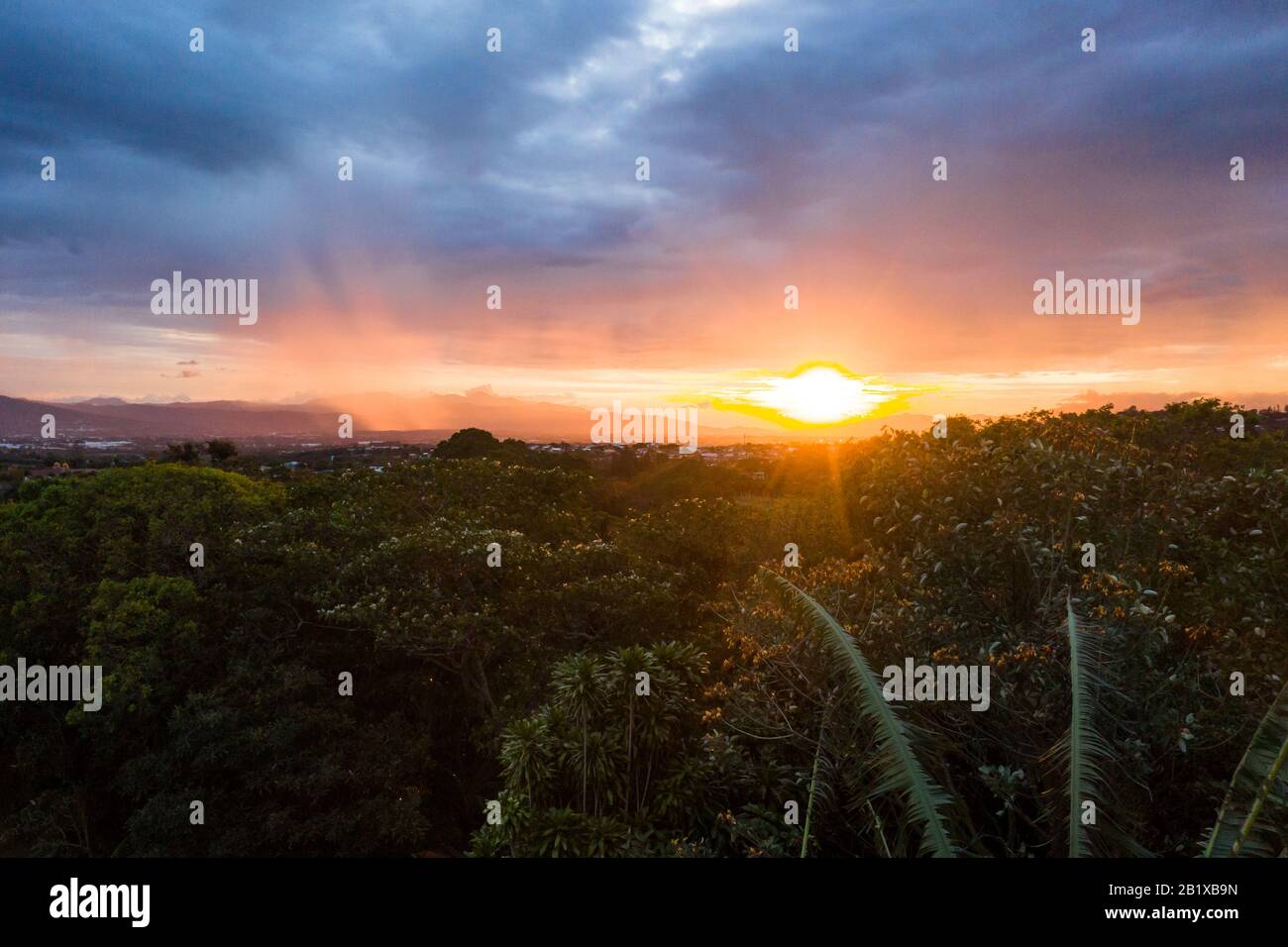 light rain falling in the valley as the setting sun adds a colorful ...
