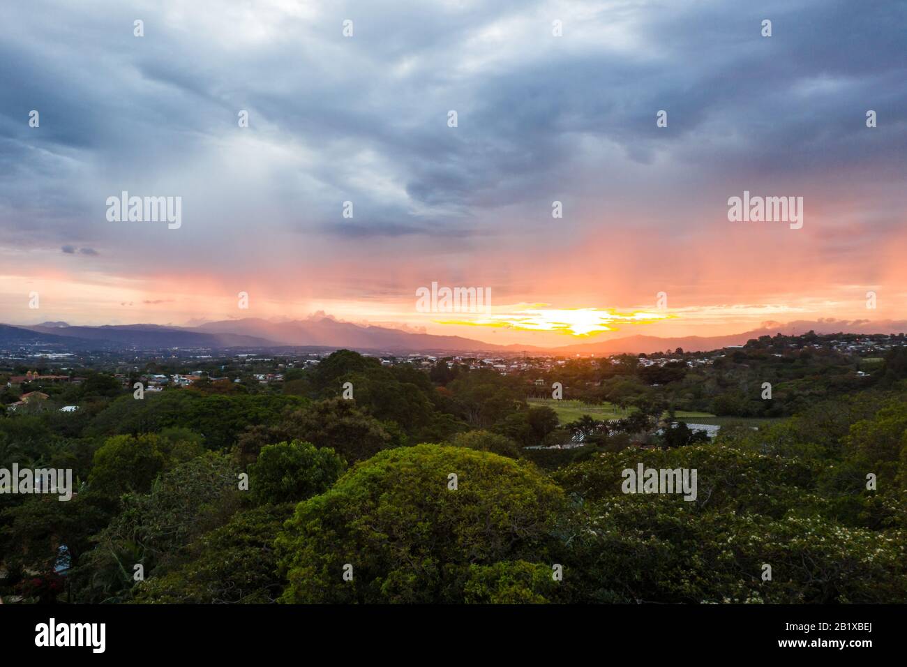 light rain falling in the valley as the setting sun adds a colorful ...
