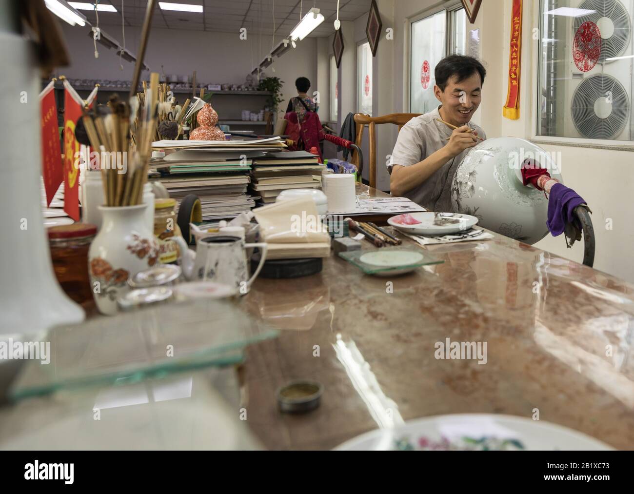 BEIJING, СHINA - JUNE 03: Chinese craftsman paints a large porcelain ...