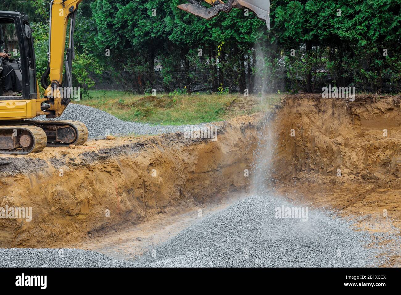 Working on a construction excavator moving gravel stones for foundation ...