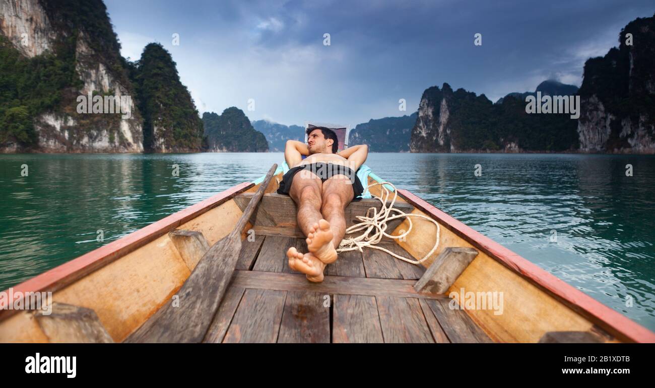 Young man sleeping on the floating boat Stock Photo - Alamy