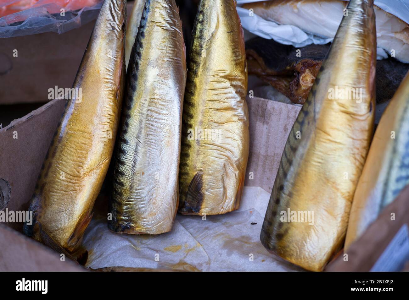 Cold-smoked mackerel in a corrugated box on the counter. Background ...