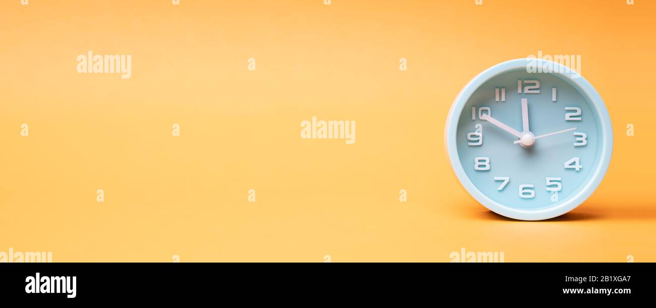 Photo Of Clock Showing 12 O'clock On Yellow Background Stock Photo - Alamy