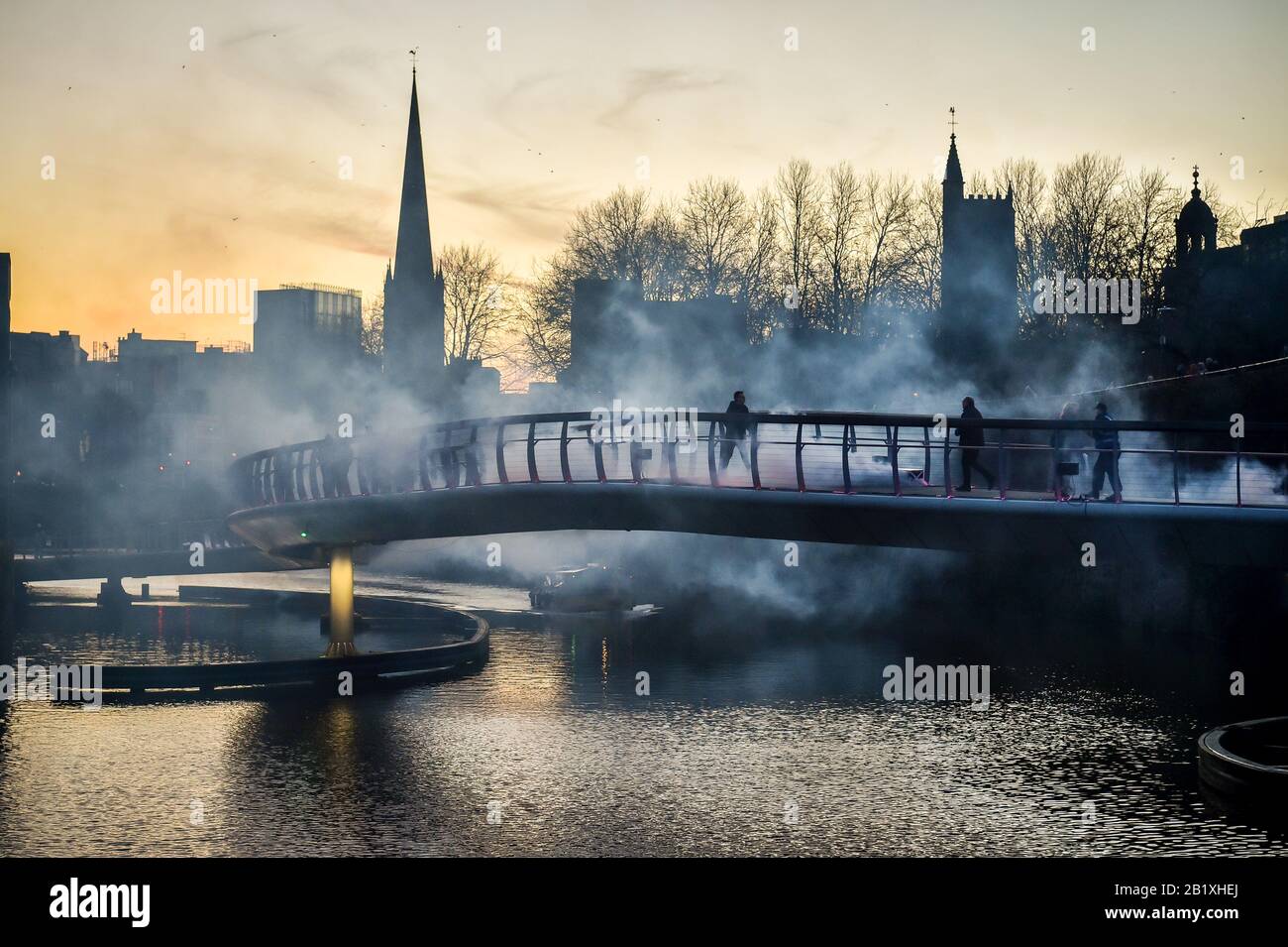 People cross Castle Bridge in Bristol before sunset, where an art ...