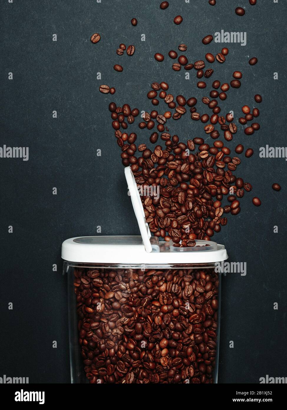 Roasted coffee beans spilled out of jar on grey background Stock Photo ...