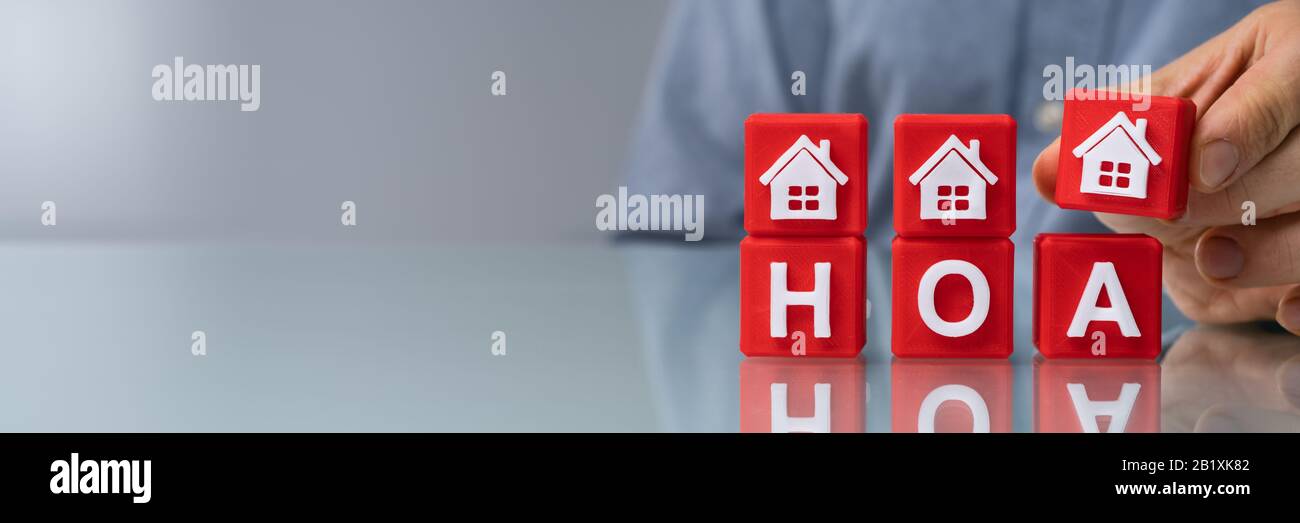 Businesswoman's Hand Placing House Models On Red HOA Cubic Blocks Over ...