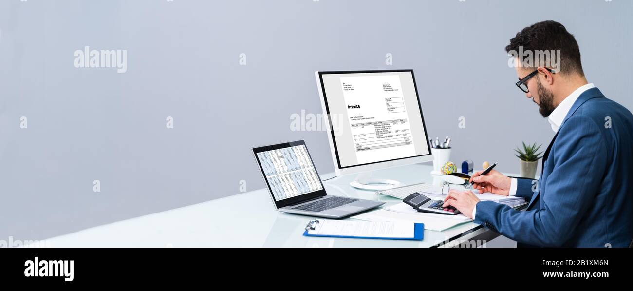 Accountant Making Invoice On Computer At Desk Stock Photo - Alamy