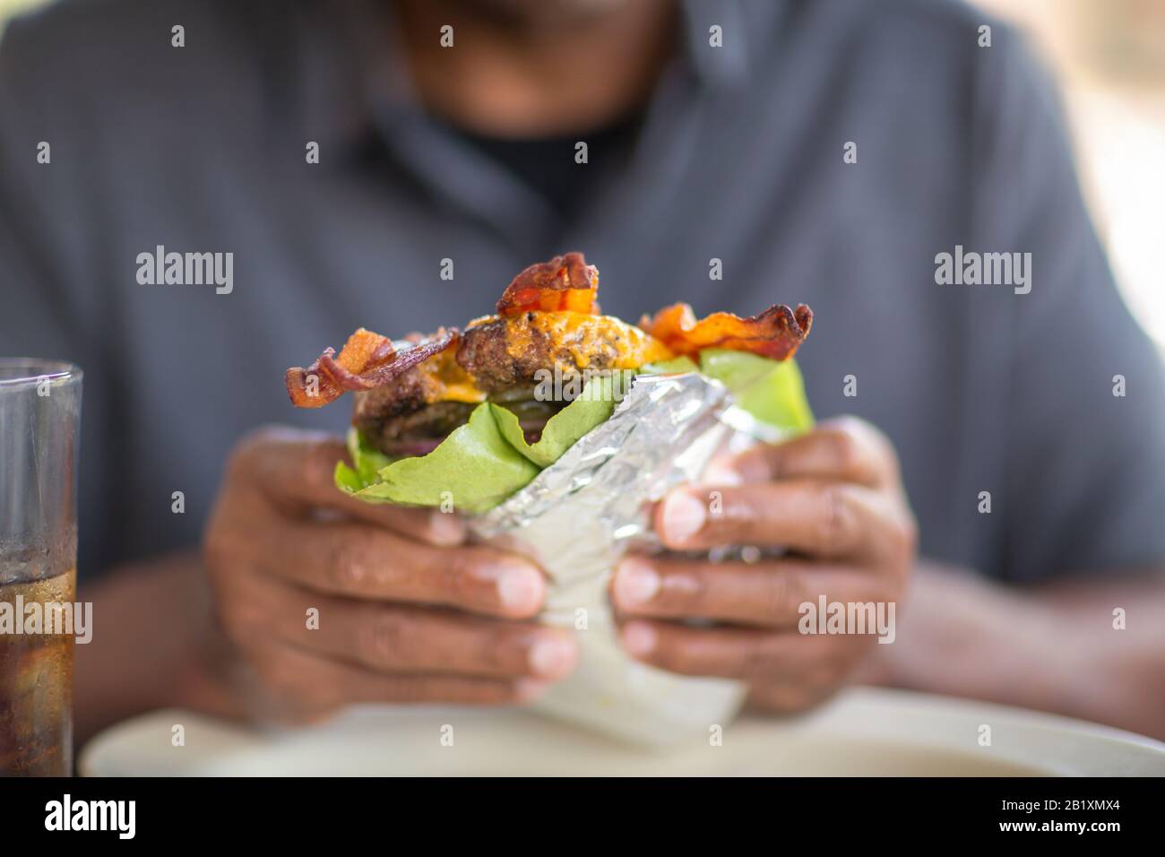 African American man eating a burger without a bun Stock Photo - Alamy