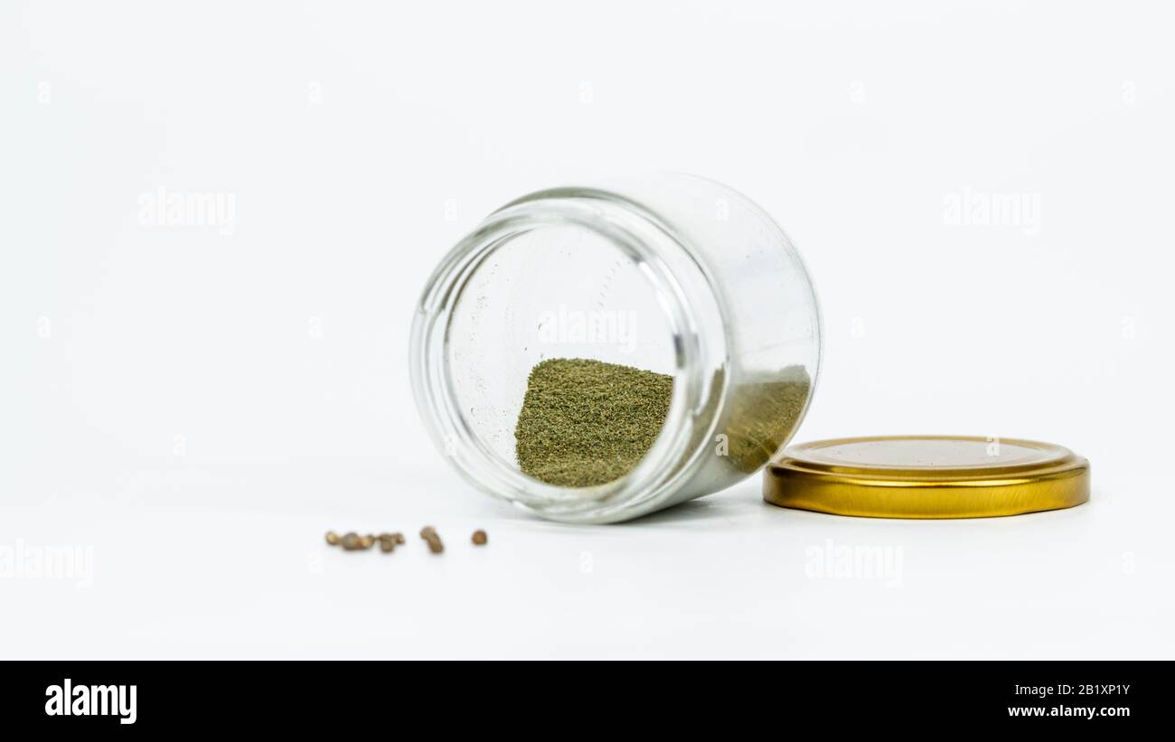 Close-up of glass jar with hashish and cannabis seeds isolated on white ...