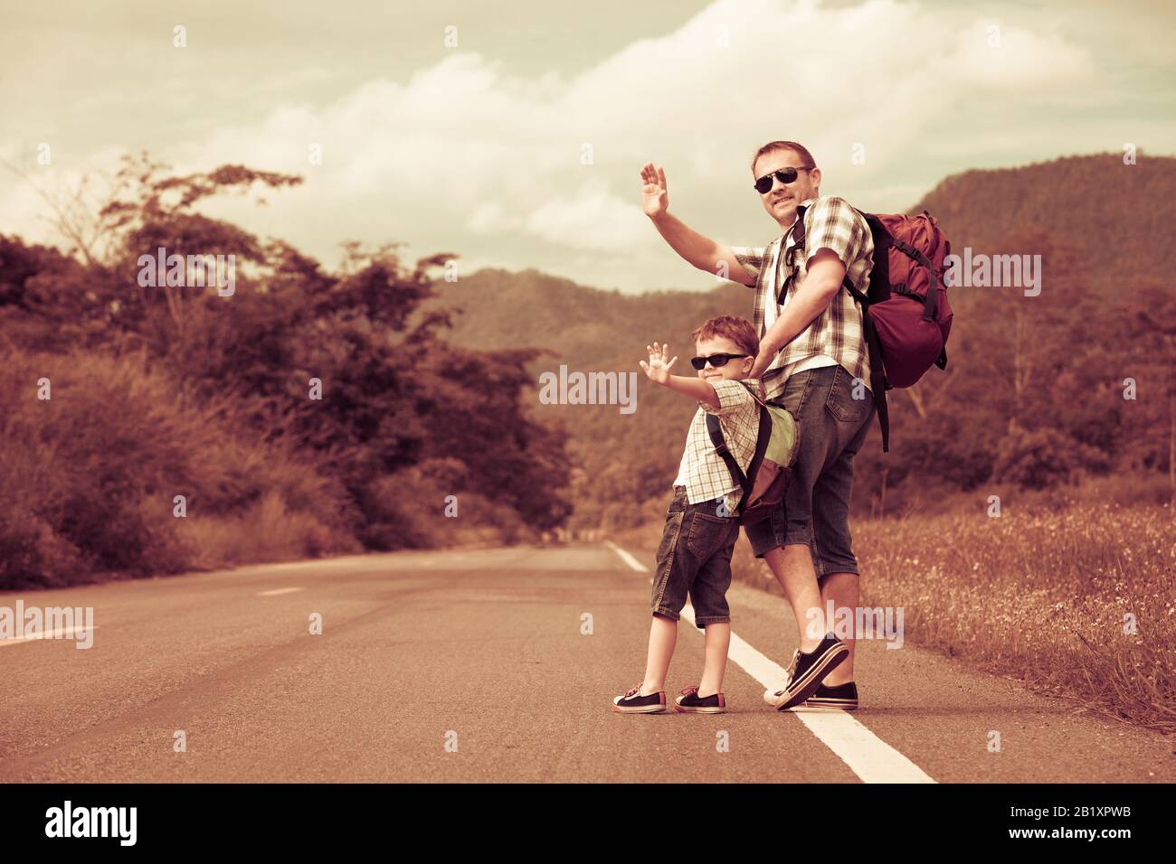 Father and son walking on the road at the day time. Concept of friendly ...