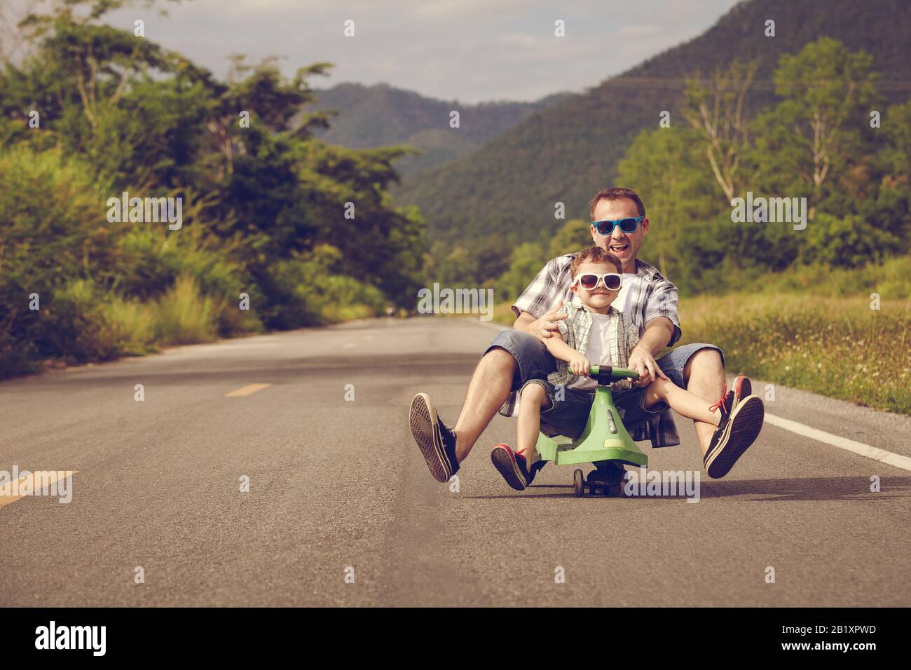 Father and son playing on the road at the day time. Concept of friendly ...