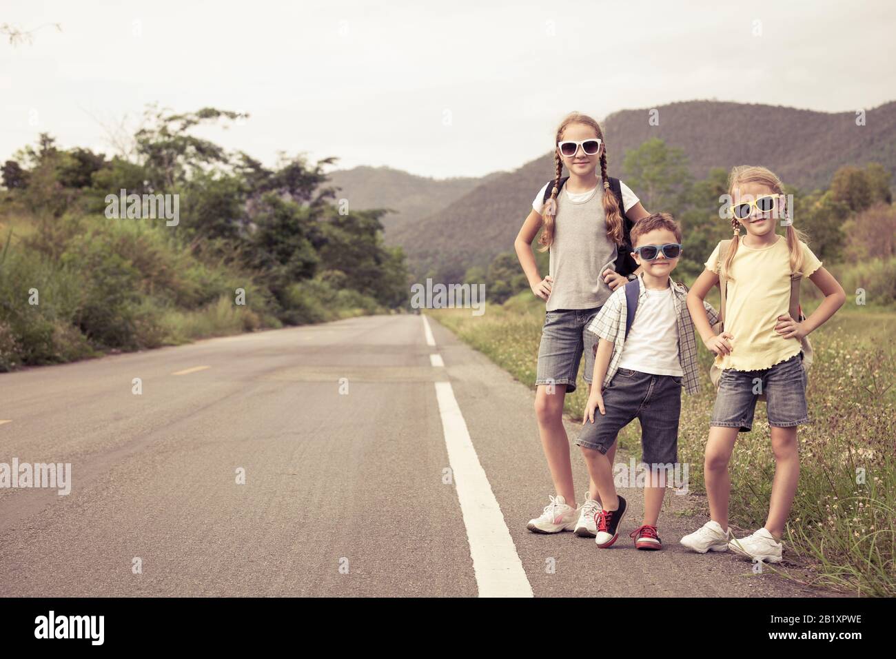 Happy children walking on the road at the day time. Concept of friendly ...